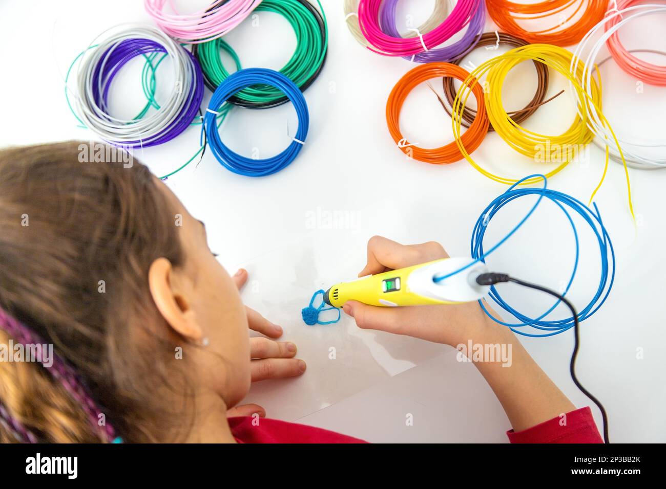 Child 3D drawings with a pen on the table. Selective focus. Kid Stock ...