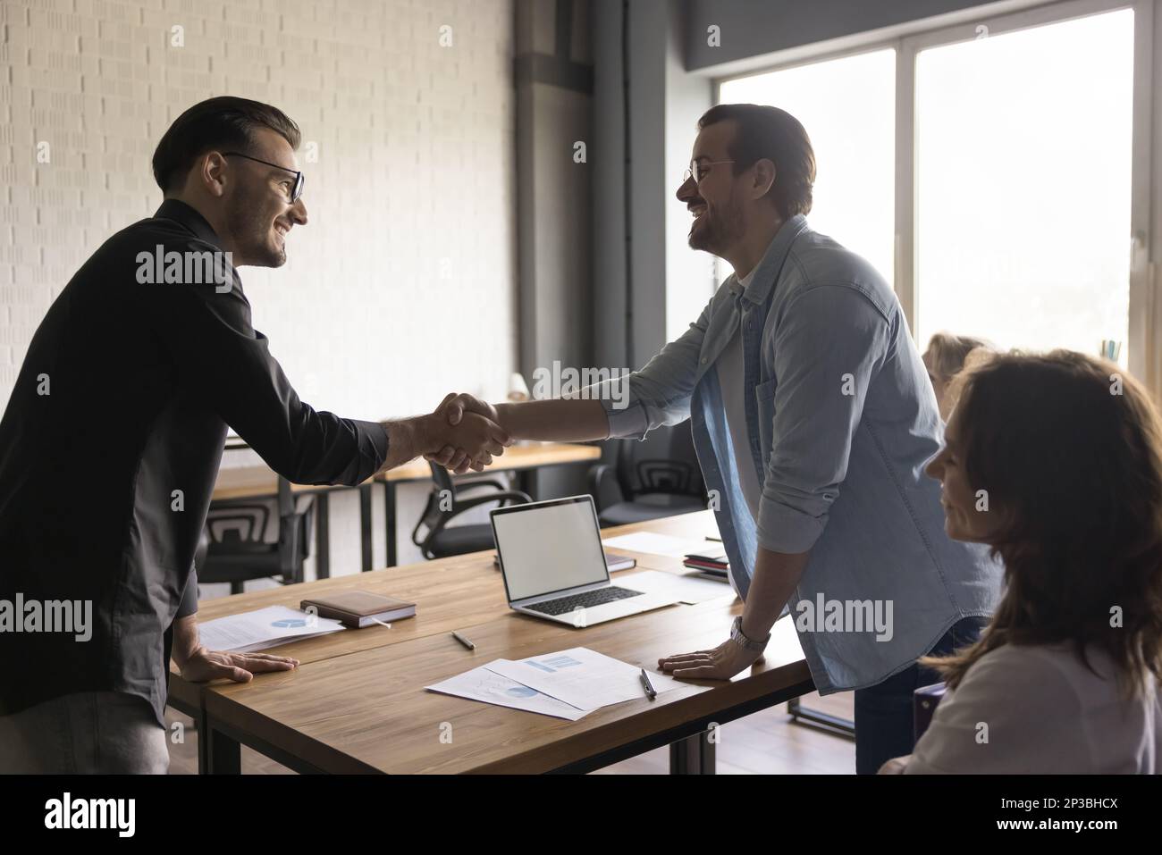 Businessmen handshake over table hi-res stock photography and images ...