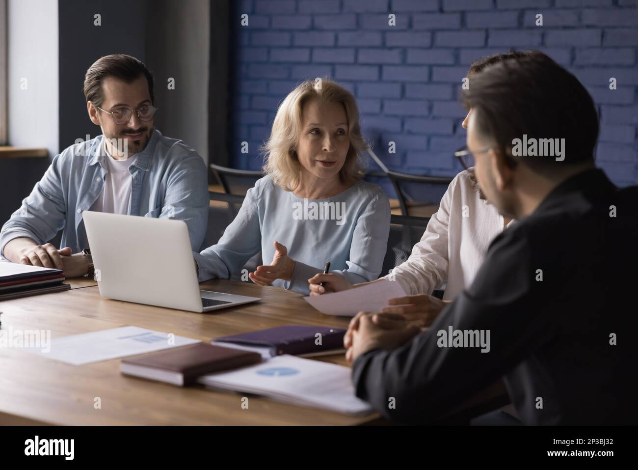 Middle aged employee woman sharing ideas, speaking on corporate meeting ...