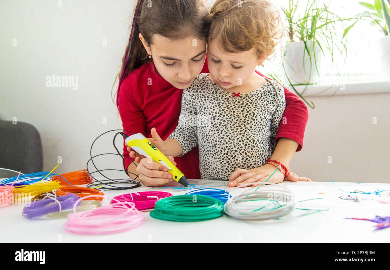 Child 3D drawings with a pen on the table. Selective focus. Kid Stock ...