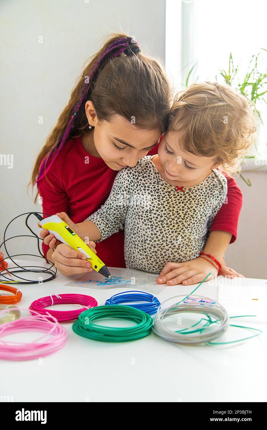 Child 3D drawings with a pen on the table. Selective focus. Kid Stock ...