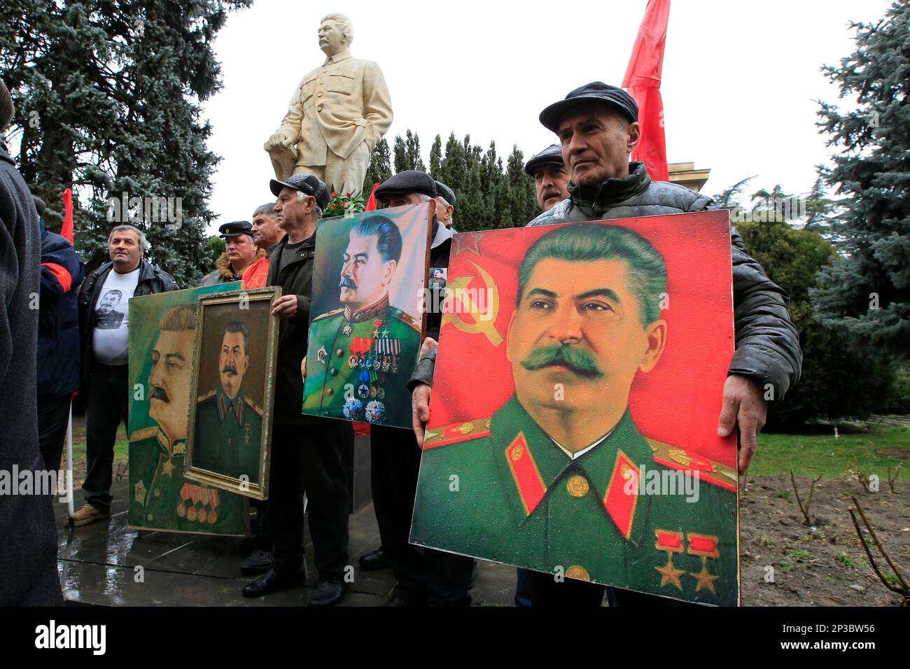 Georgians stand with portraits of former Soviet dictator Joseph Stalin ...
