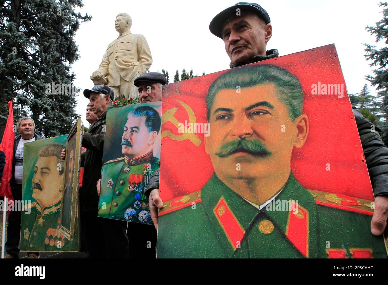 Georgians stand with portraits of former Soviet dictator Joseph Stalin ...