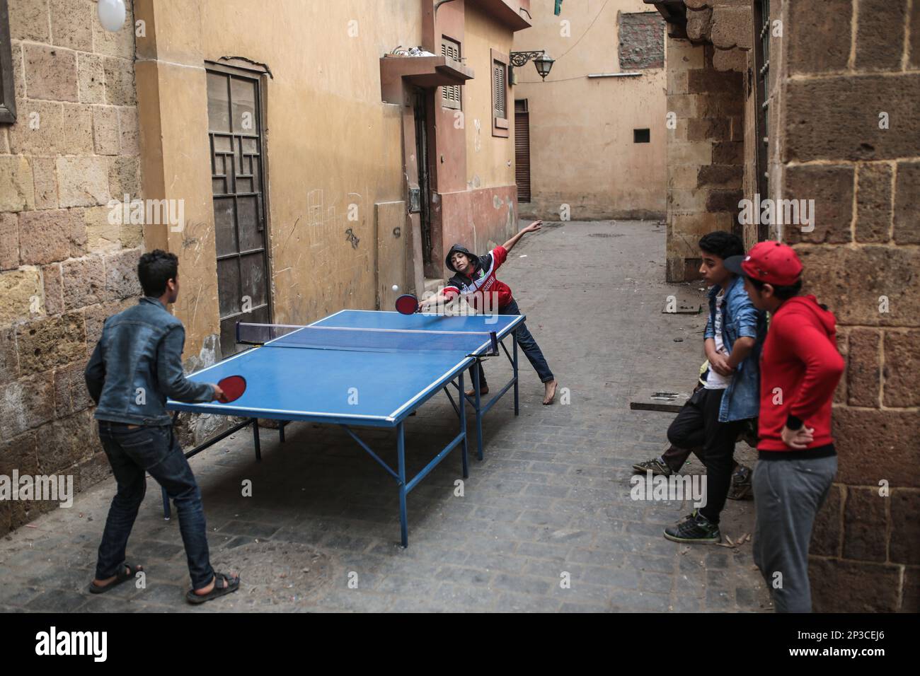 Egyptian boys play table tennis in an alleyway in Islamic Cairo, Egypt ...
