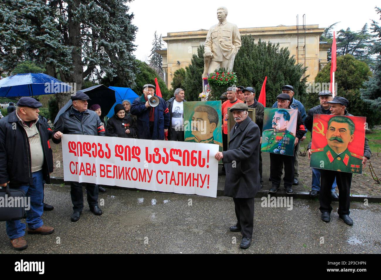 Georgians stand with portraits of former Soviet dictator Joseph Stalin ...