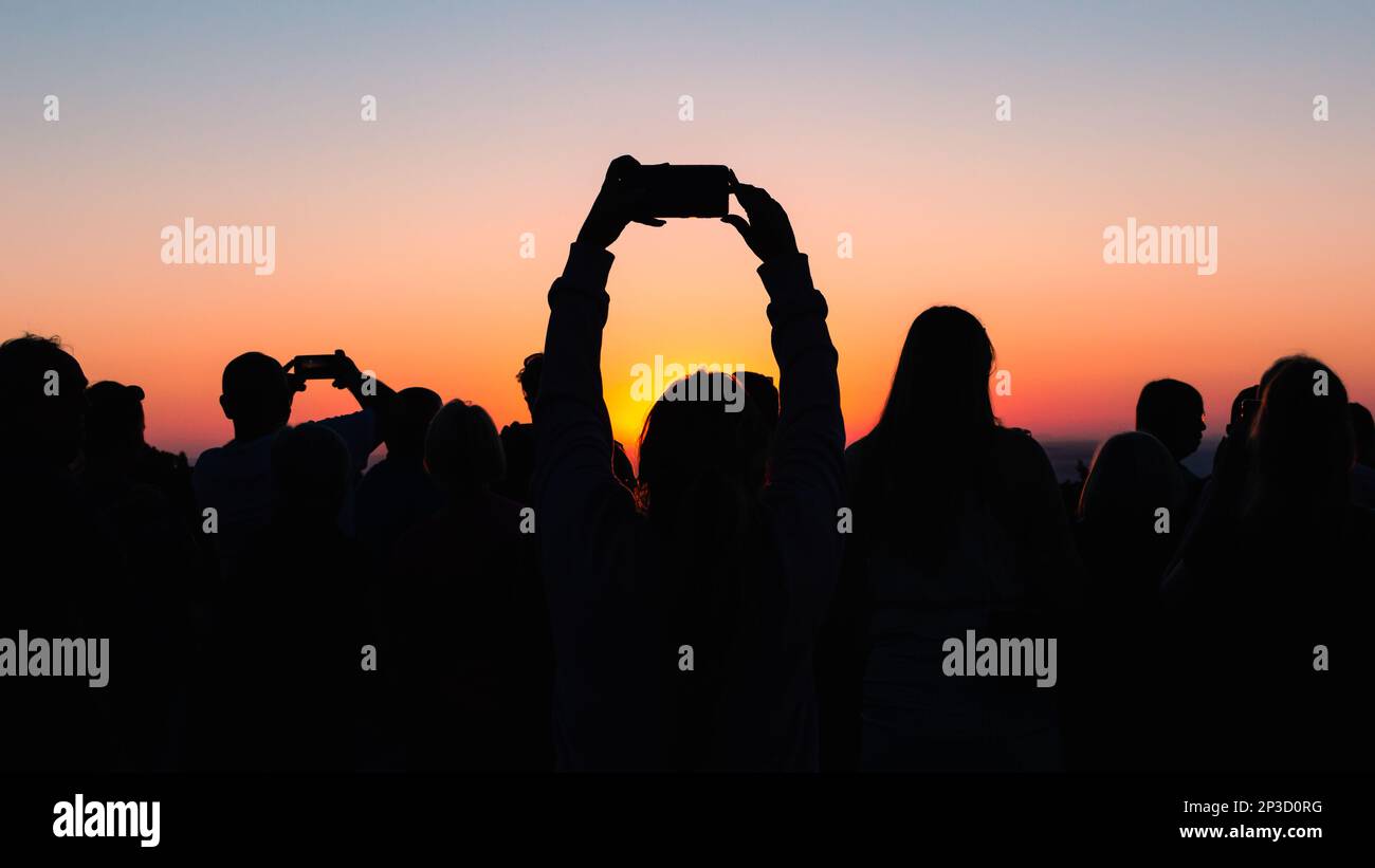 Silhouette of people photographing the sunset in the Greek Town of Zia ...