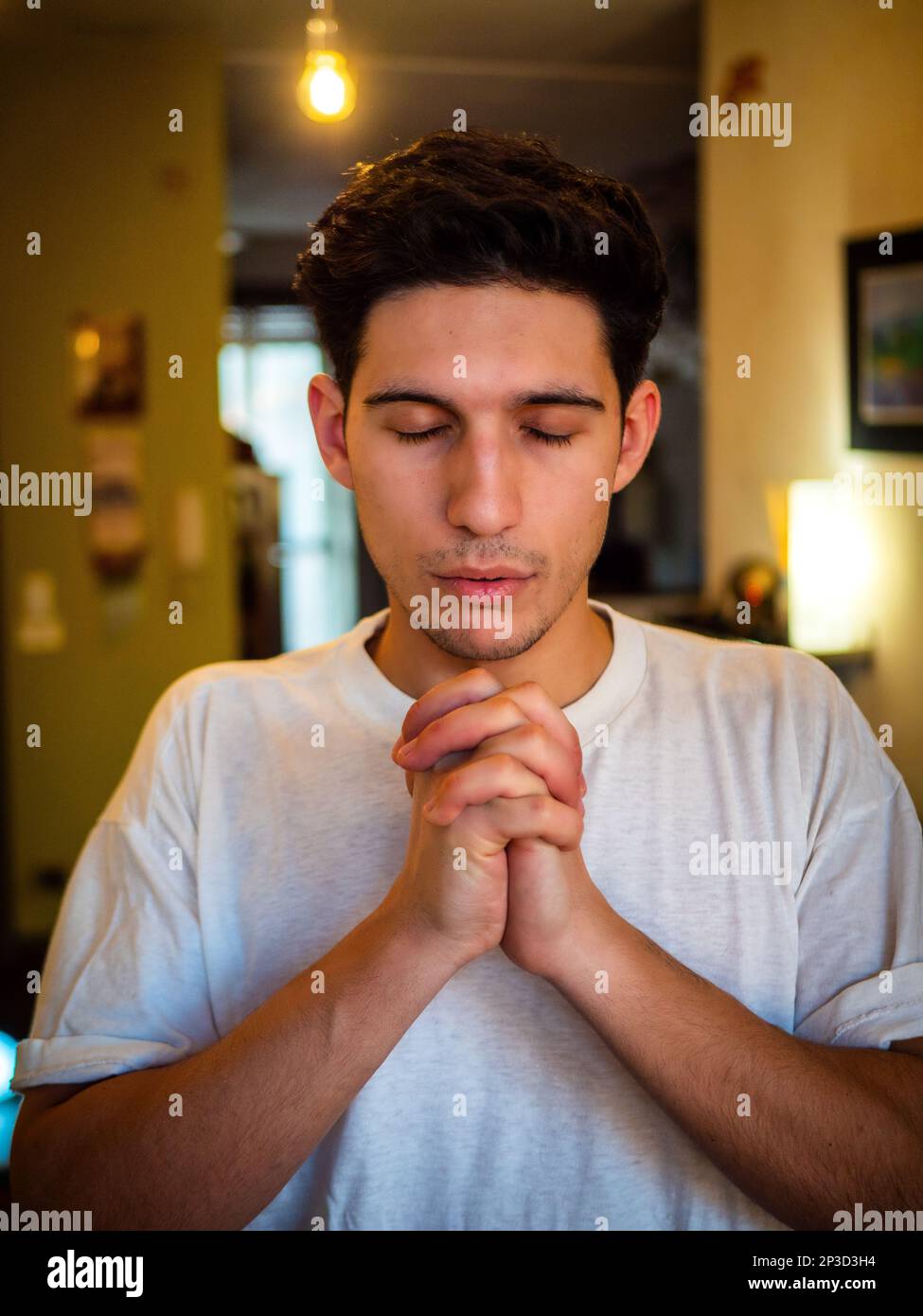 Young man pleading with hands joined praying Stock Photo - Alamy