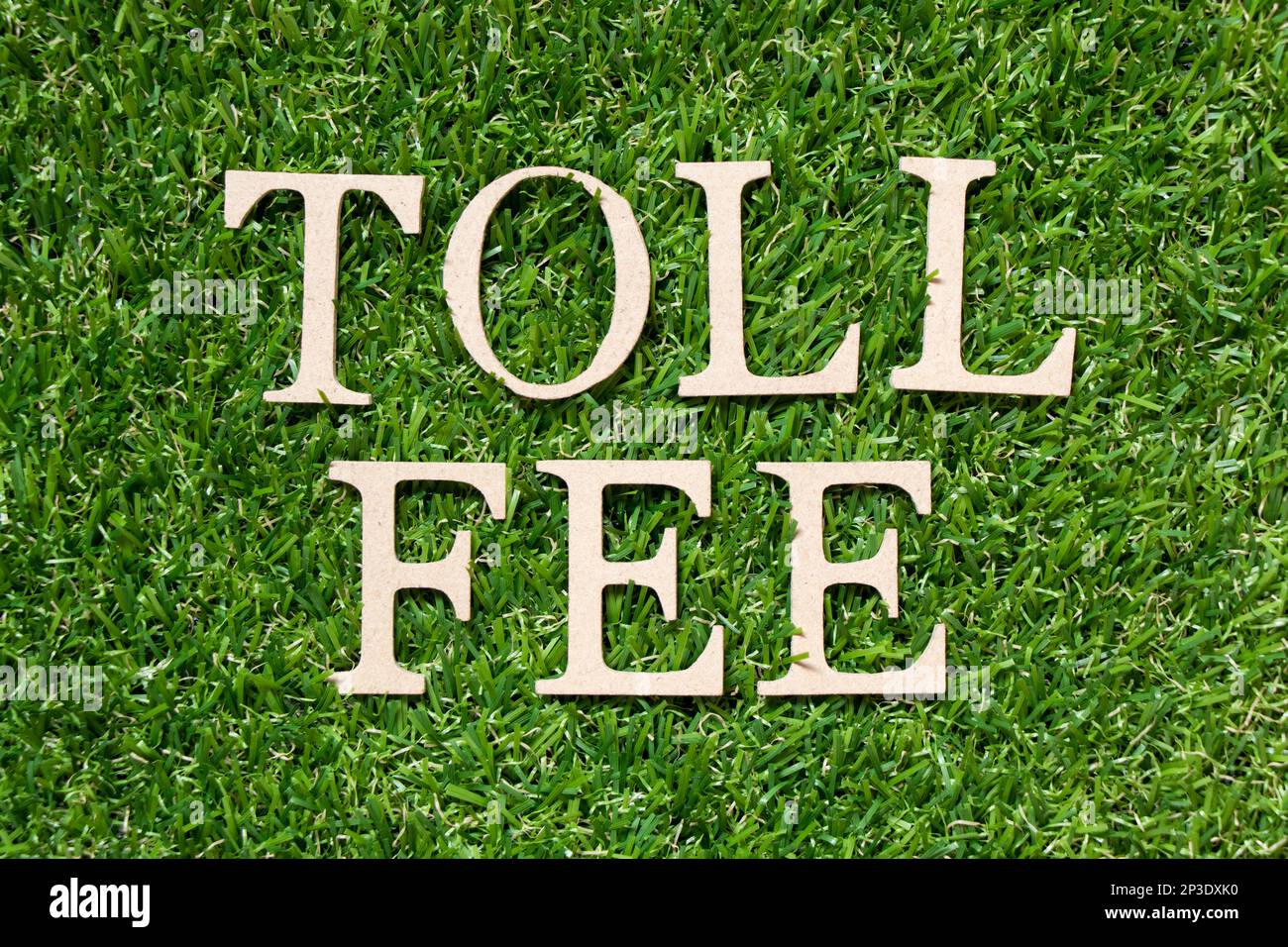 Wood alphabet letter in word toll fee on artificial green grass ...