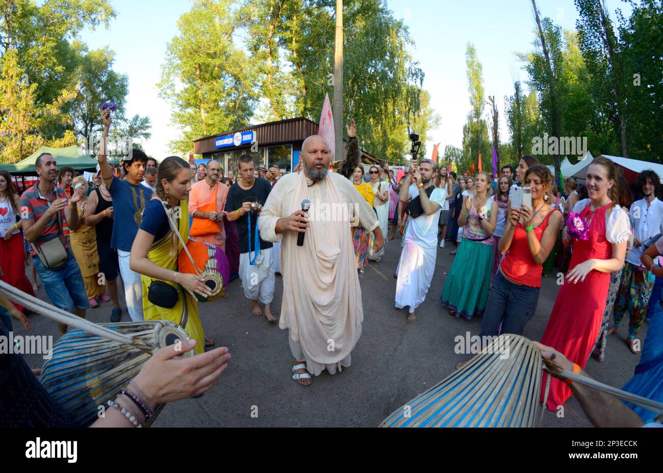 Krishna guru preaching with microphone standing among crowd of ...