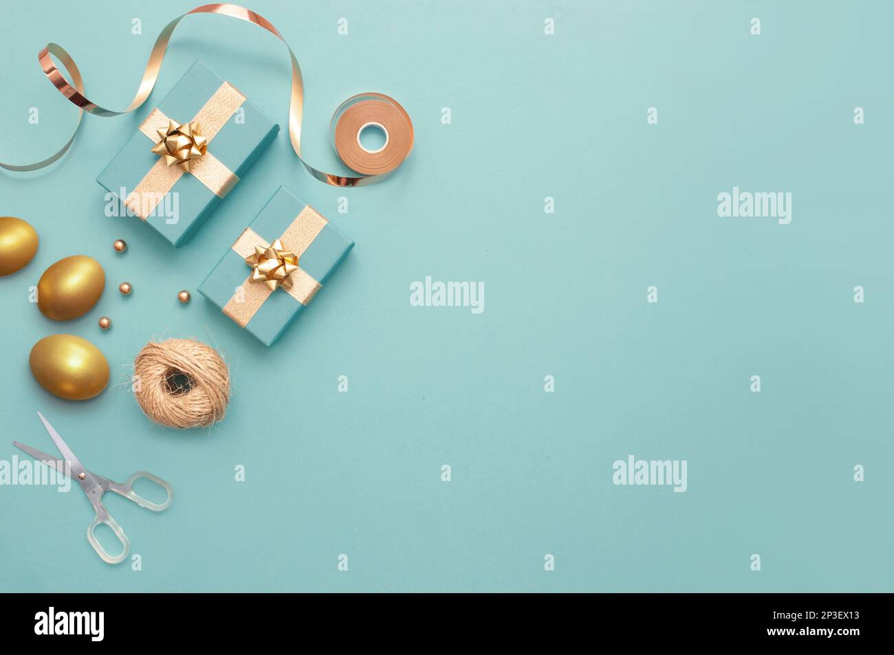 Top view of easter gift boxes wrapped in gold with gold eggs, and ...