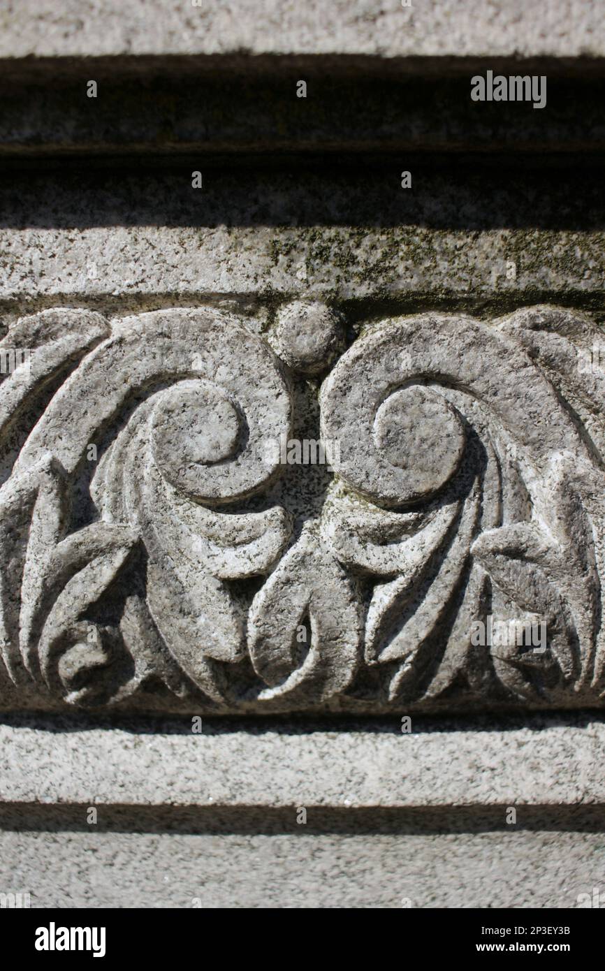 A vintage natural stone wall with elaborate scrolls carved into the ...