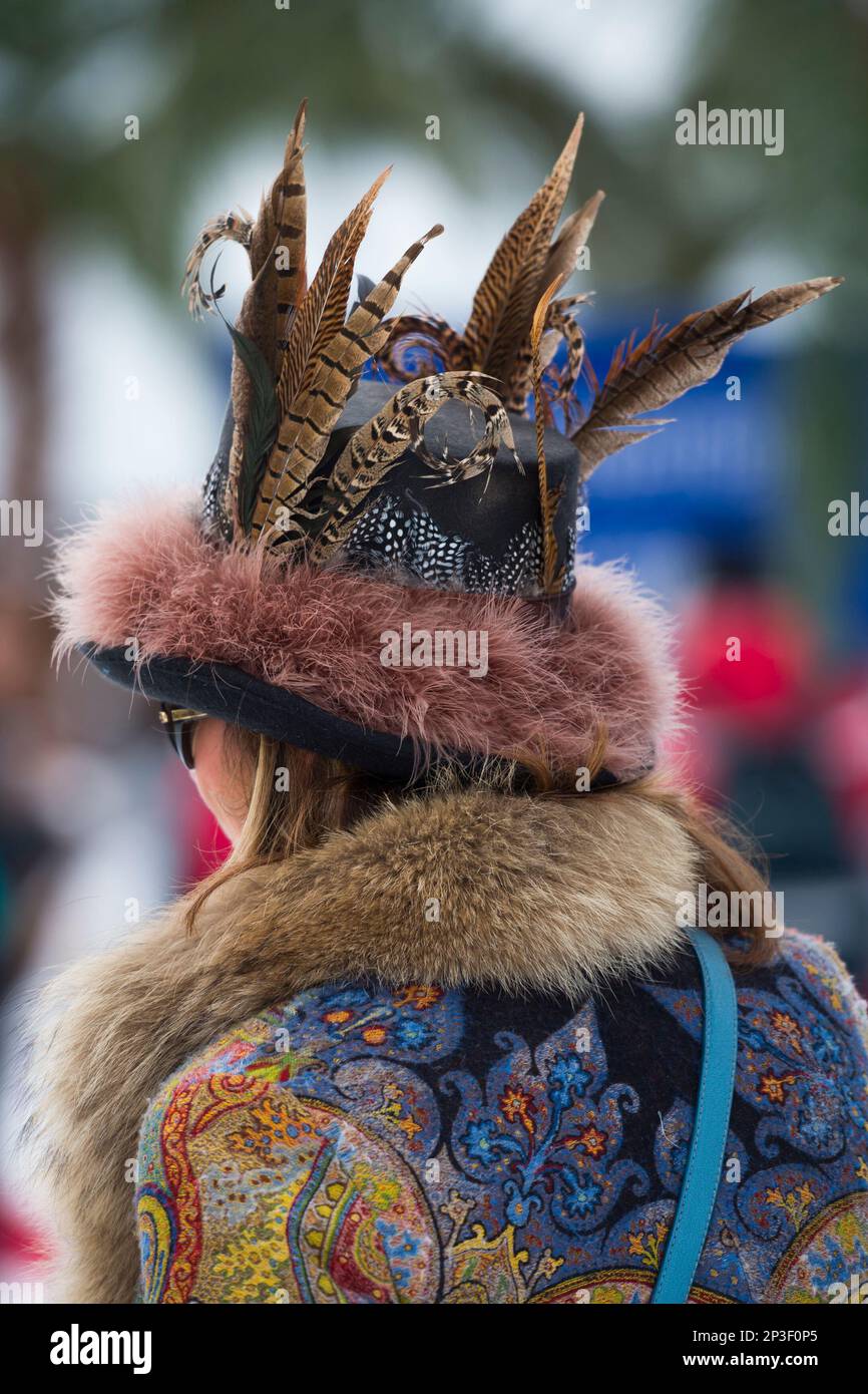 A woman wears a fancy fur cap with feathers on the frozen Lake of St ...