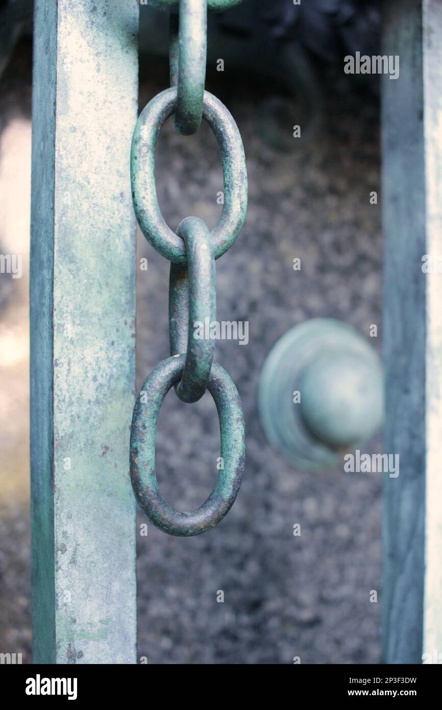 A copper metal chain hanging from a gate Stock Photo - Alamy