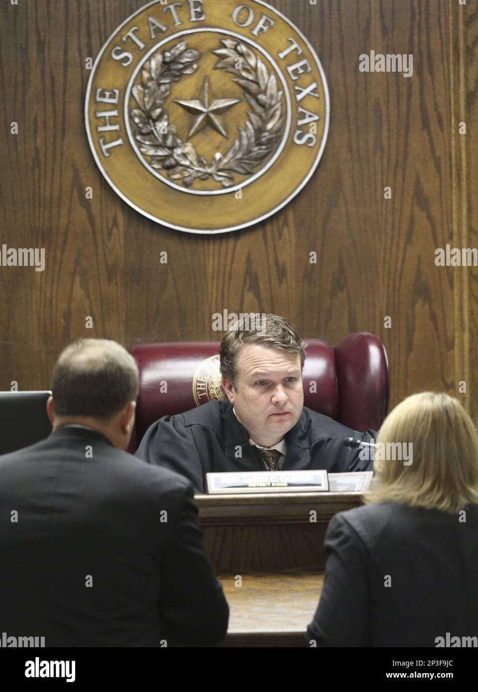 State District Judge Jason Cashon, center, speaks to defense attorney ...