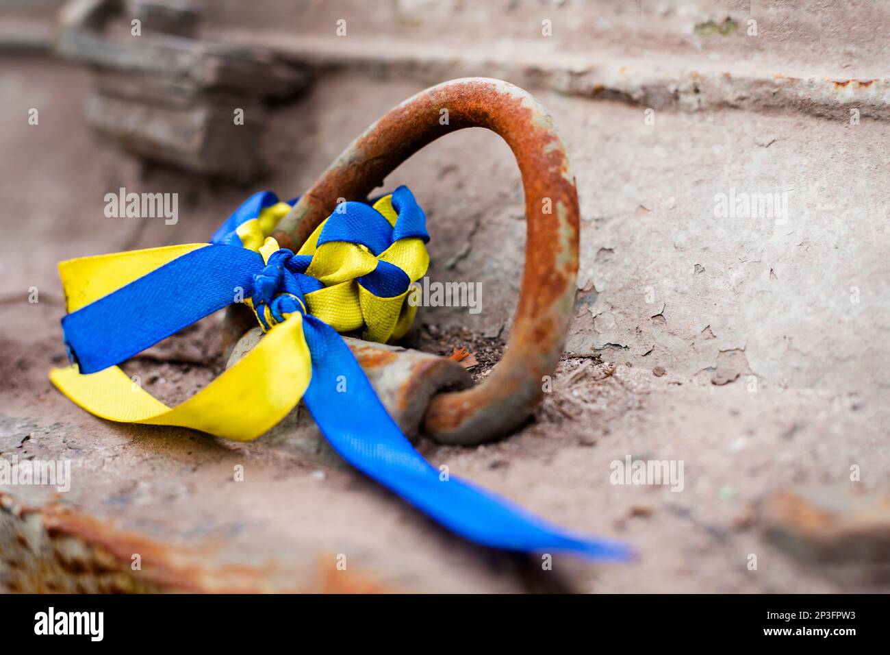 blue-yellow Ukrainian ribbon as a symbol tied to a weapon. War with ...