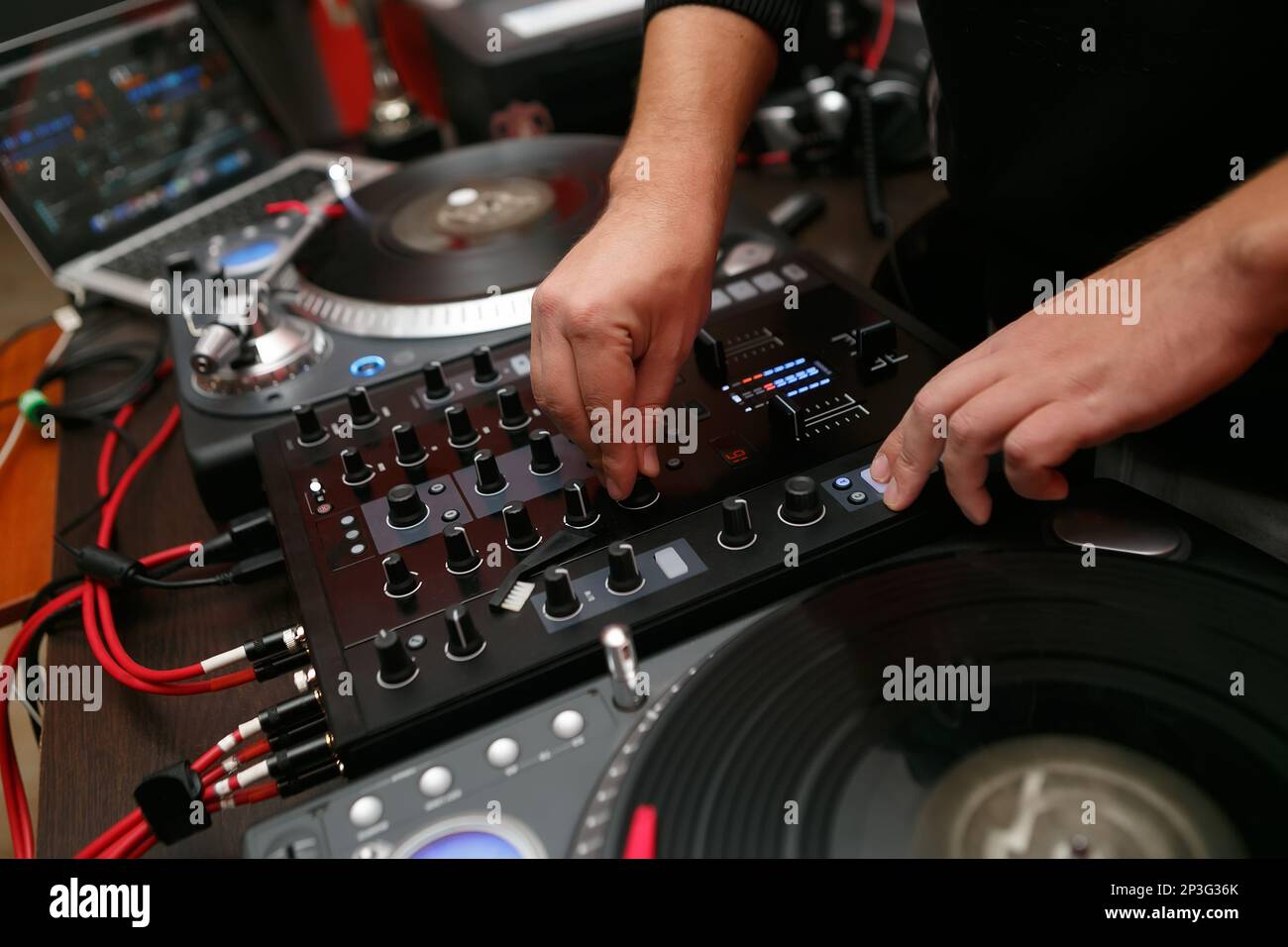Hip hop DJ mixing vinyl records on turn table in close up. Professional ...