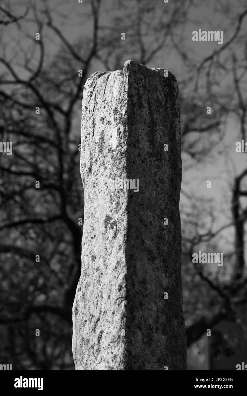 A worn and weathered simple stone tower in a black and white monochrome ...