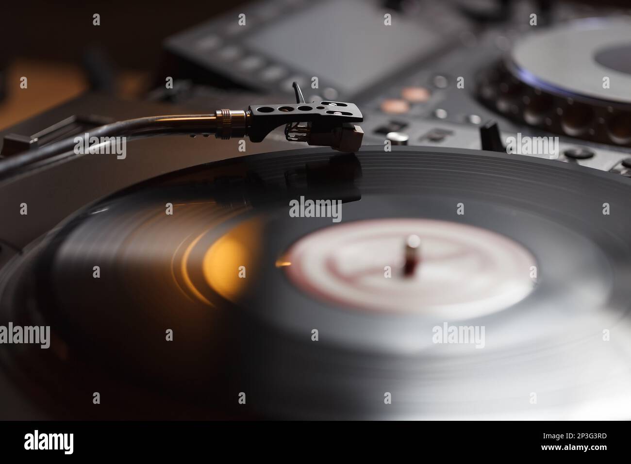 Turntables needle playing music from analog vinyl disc in close up ...
