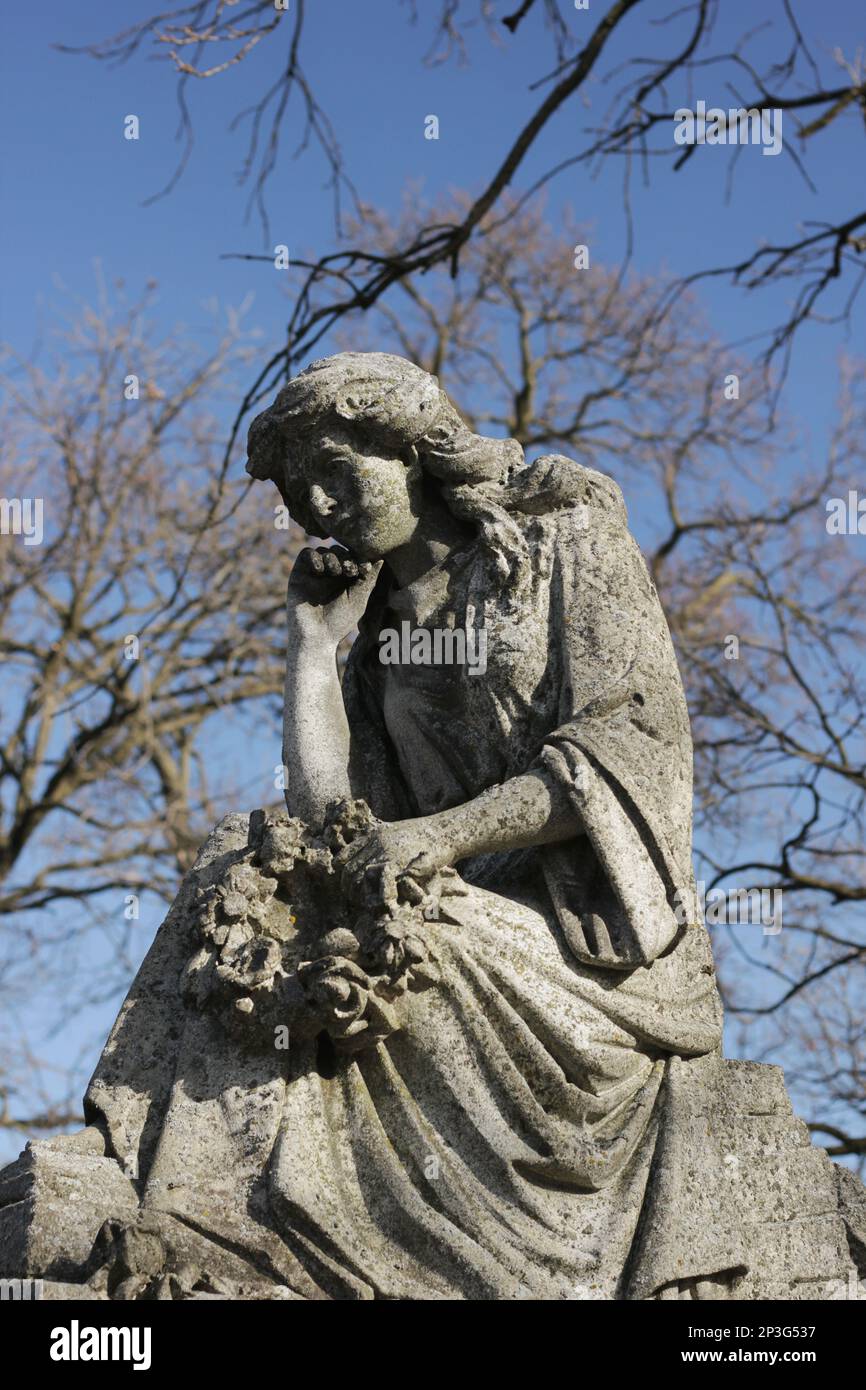 A grieving young woman carved into a natural stone statue Stock Photo ...