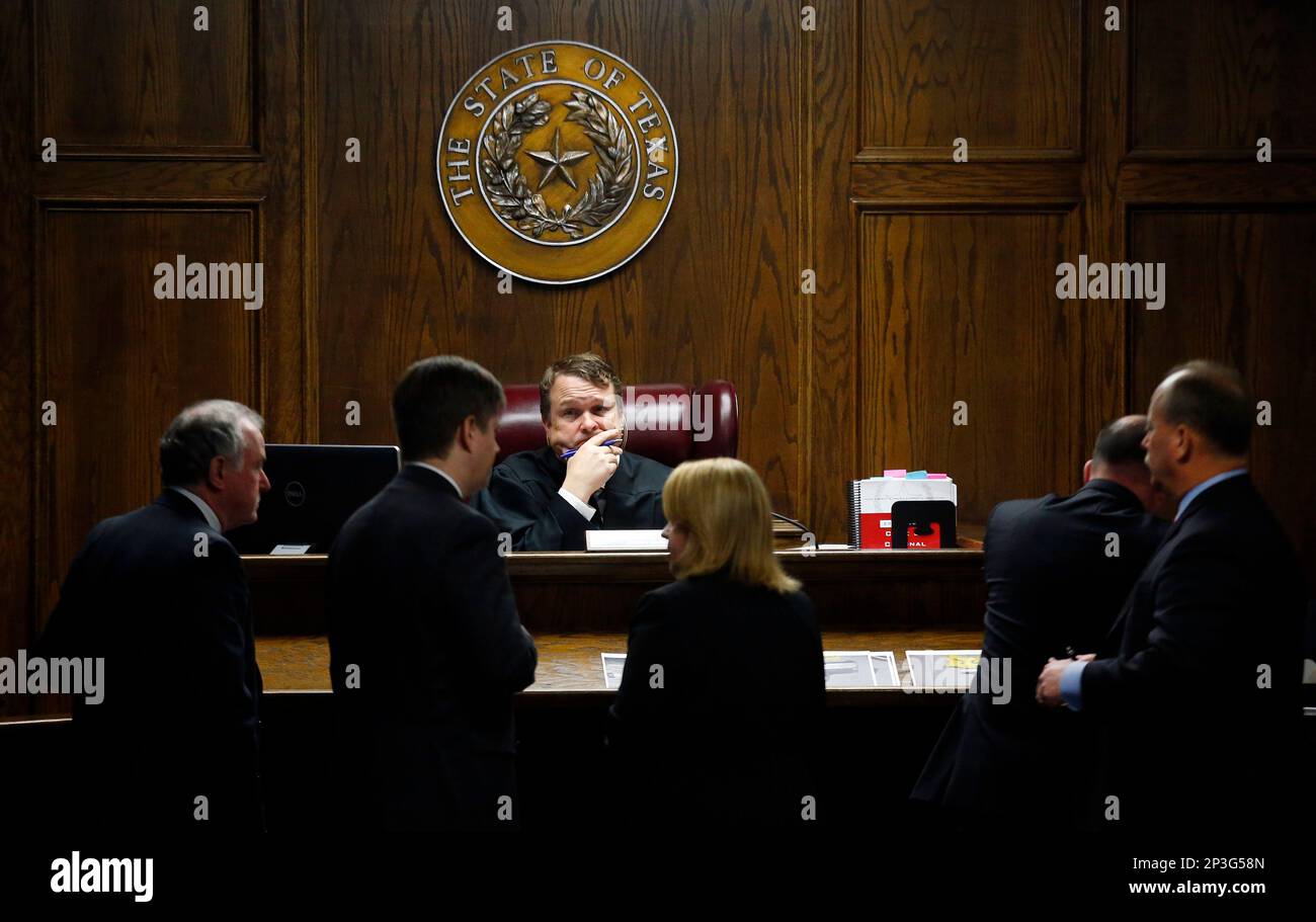 State District Judge Jason Cashon, center, listens to arguments from ...