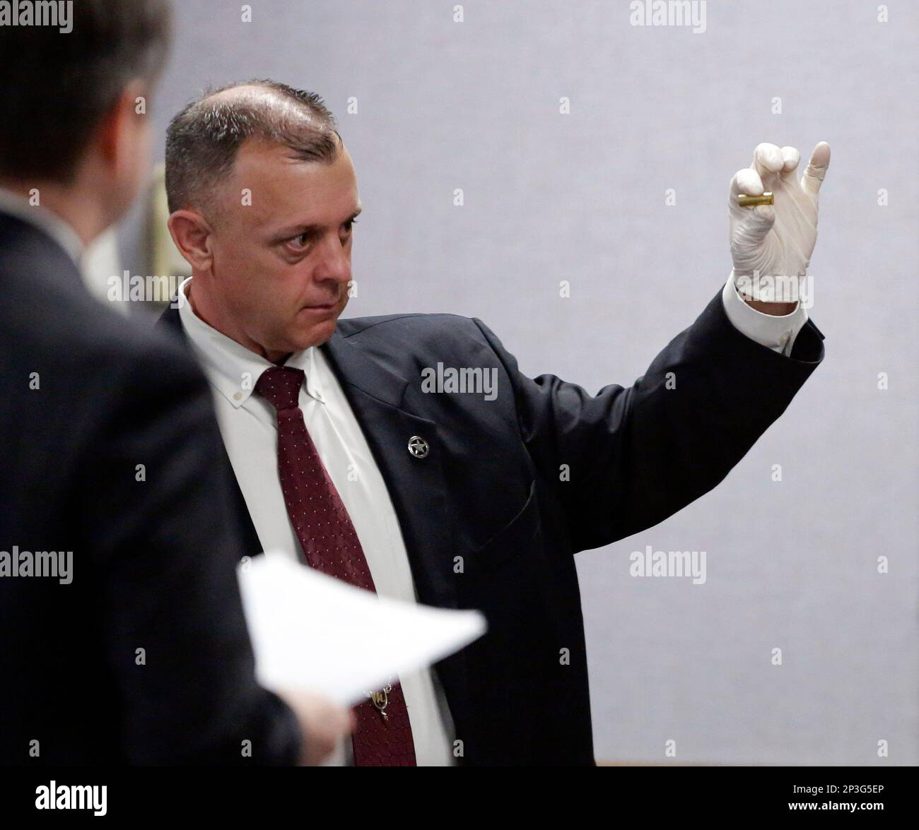 Texas Ranger Michael Adcock shows the jury a shell casing from the ...