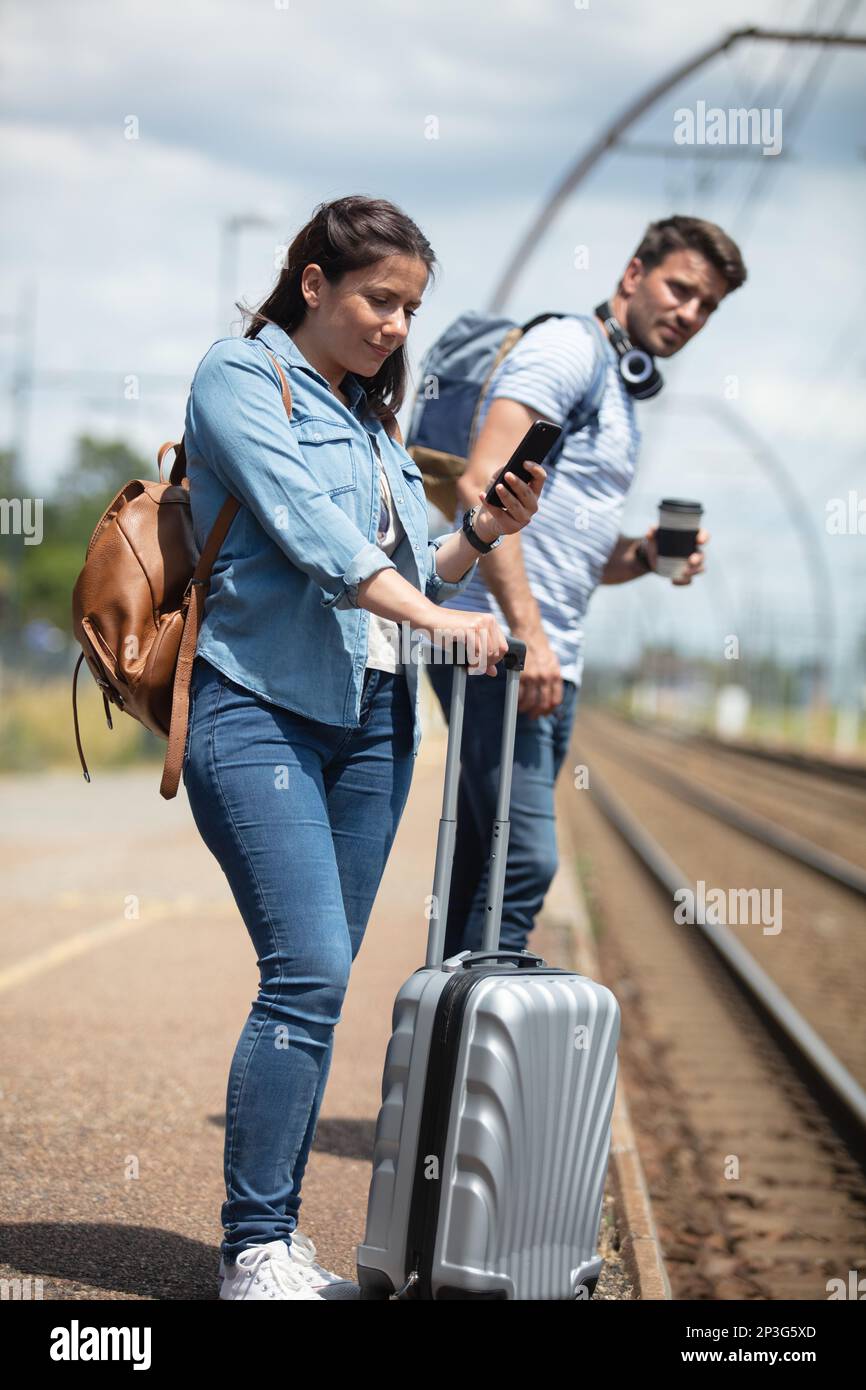 couple at railway station wiring for train travel concept Stock Photo ...