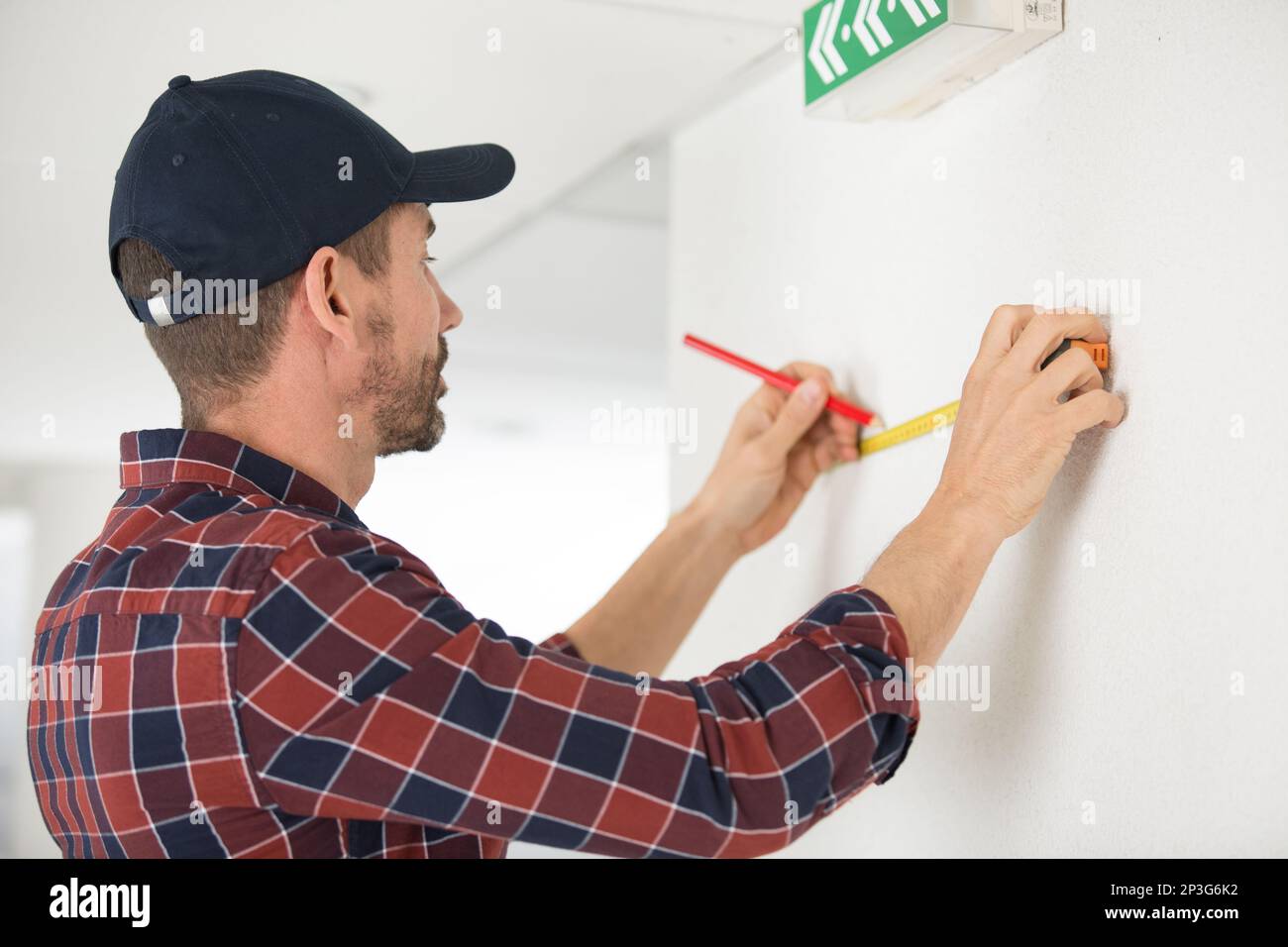 man measuring wall and marking position Stock Photo - Alamy