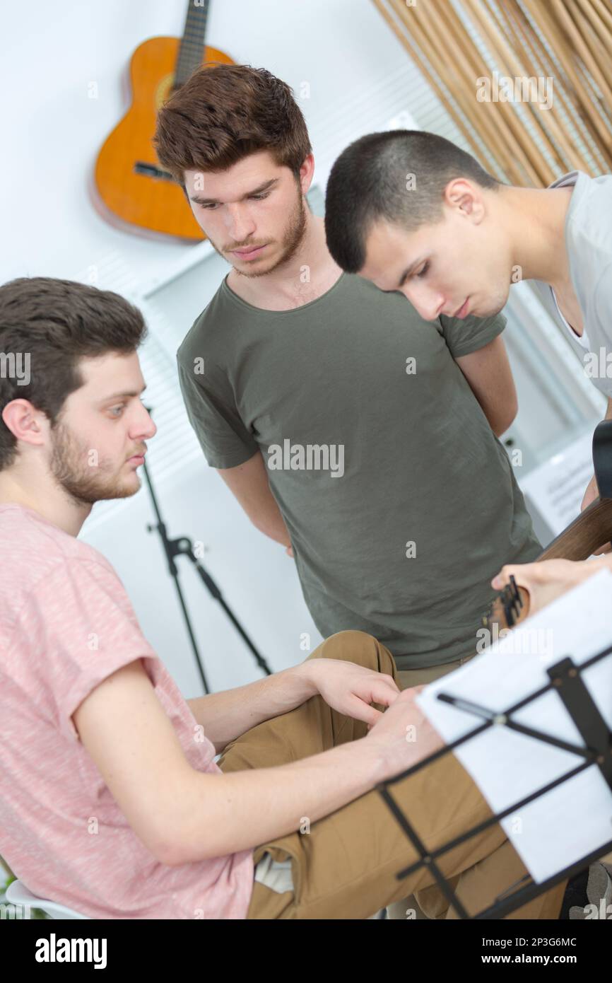 three young male musicians together one with guitar Stock Photo - Alamy
