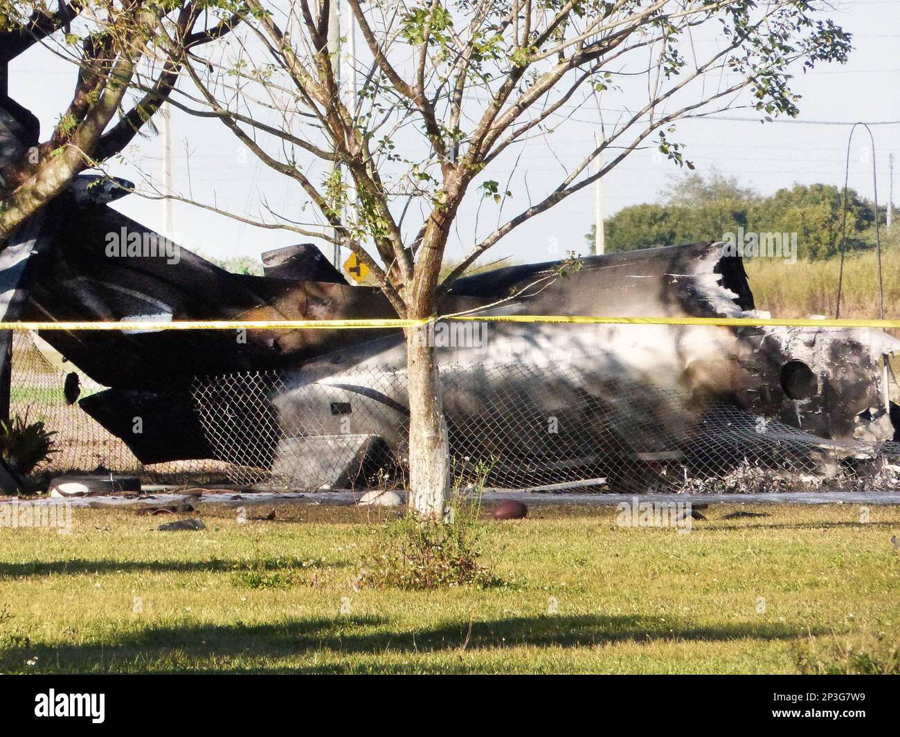Debris of a Beechcraft 1900 twin-engine propeller plane lies on a field ...