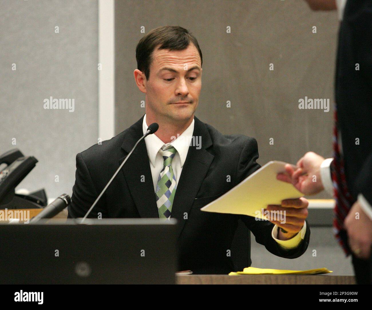 Dr. Jonathan Thompson inspects documents during his testimony in ...