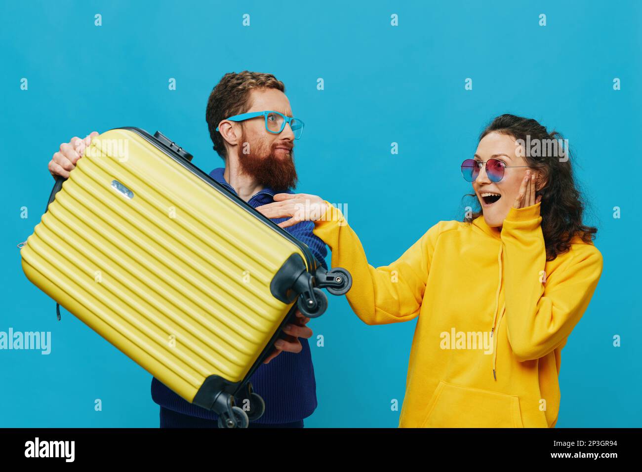 Woman and man smile sitting on suitcase with yellow suitcase smile, on ...