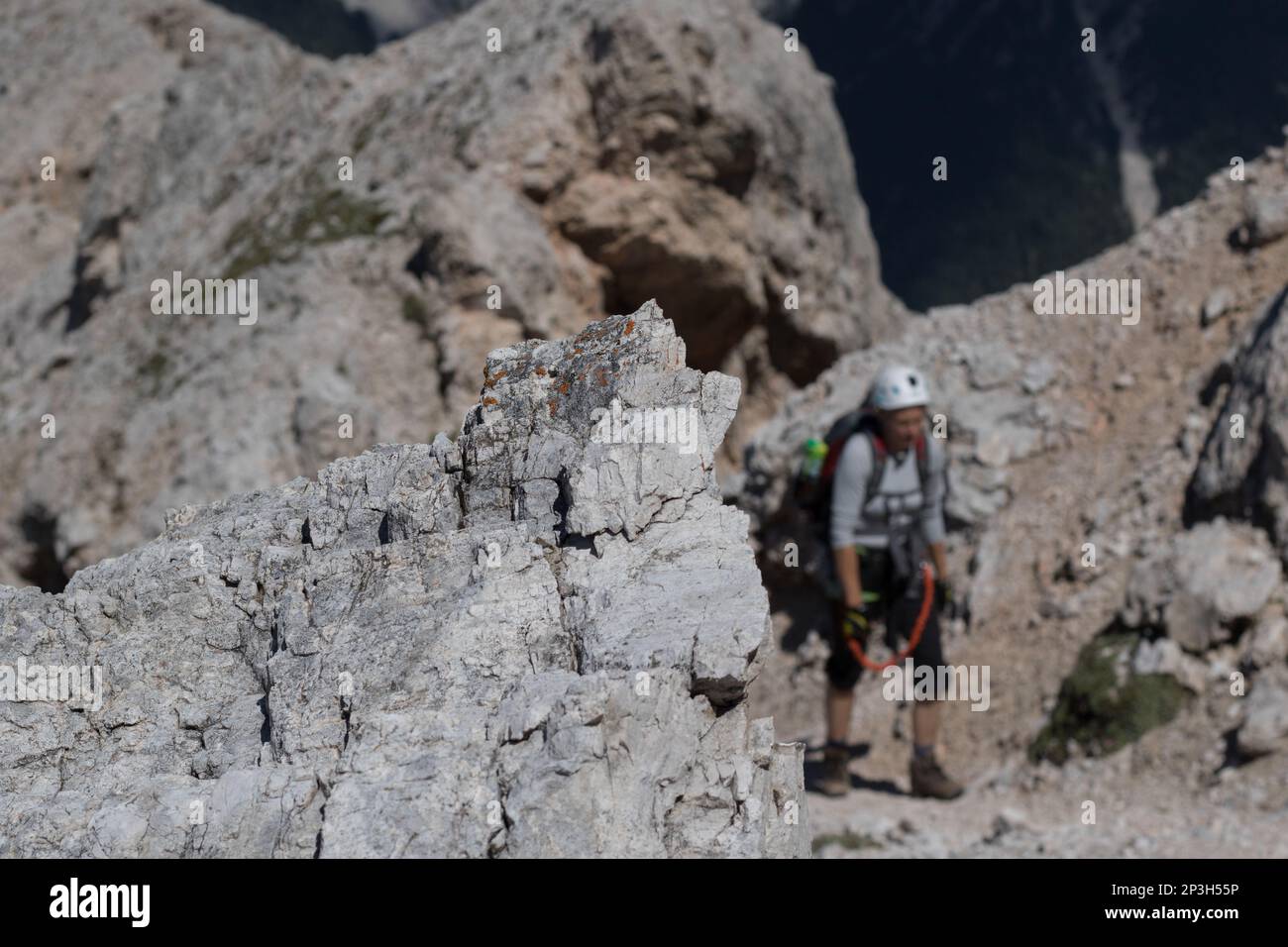 Tourist crossing the via ferrata trail with equipment in the dolomites ...