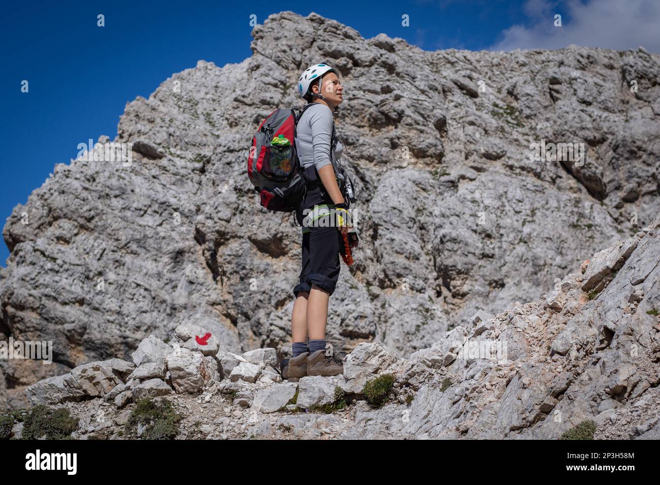 Tourist crossing the via ferrata trail with equipment in the dolomites ...