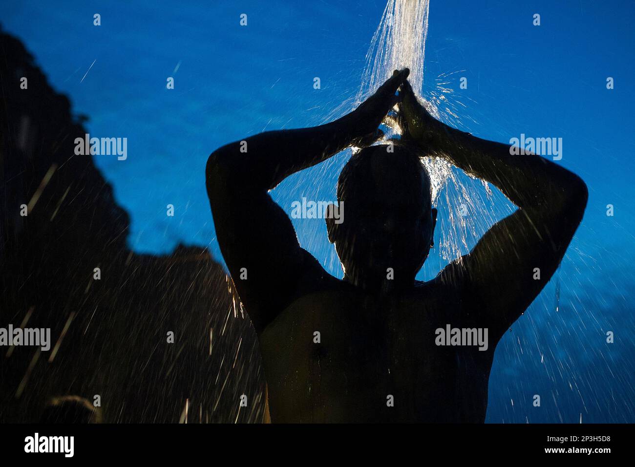 A Hindu devotee takes a shower as part of a cleaning ritual before his ...