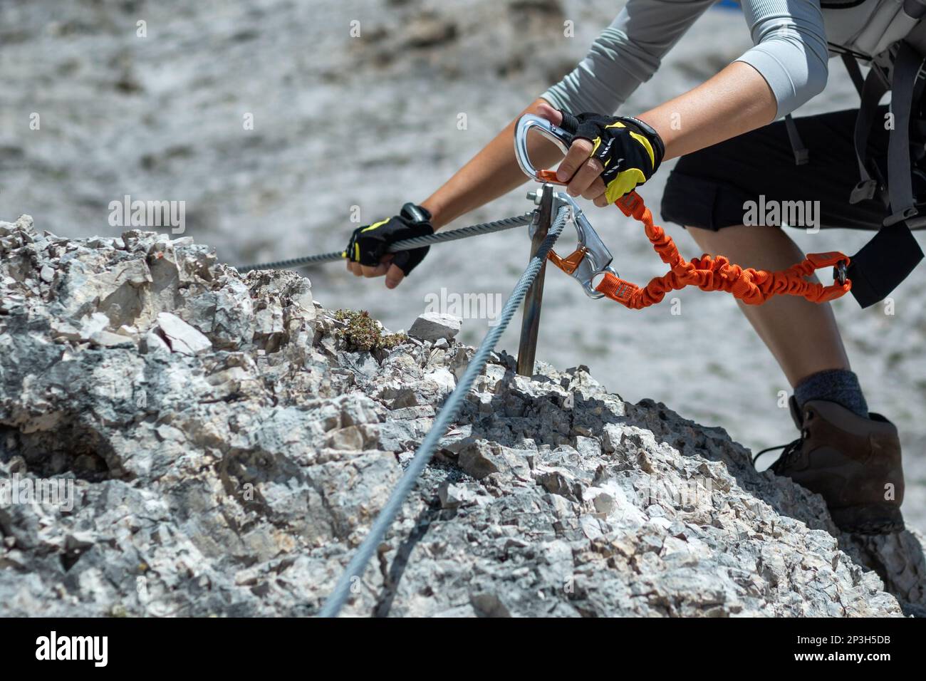 Climbing along a steel line on the via ferrata route in the dolomites ...