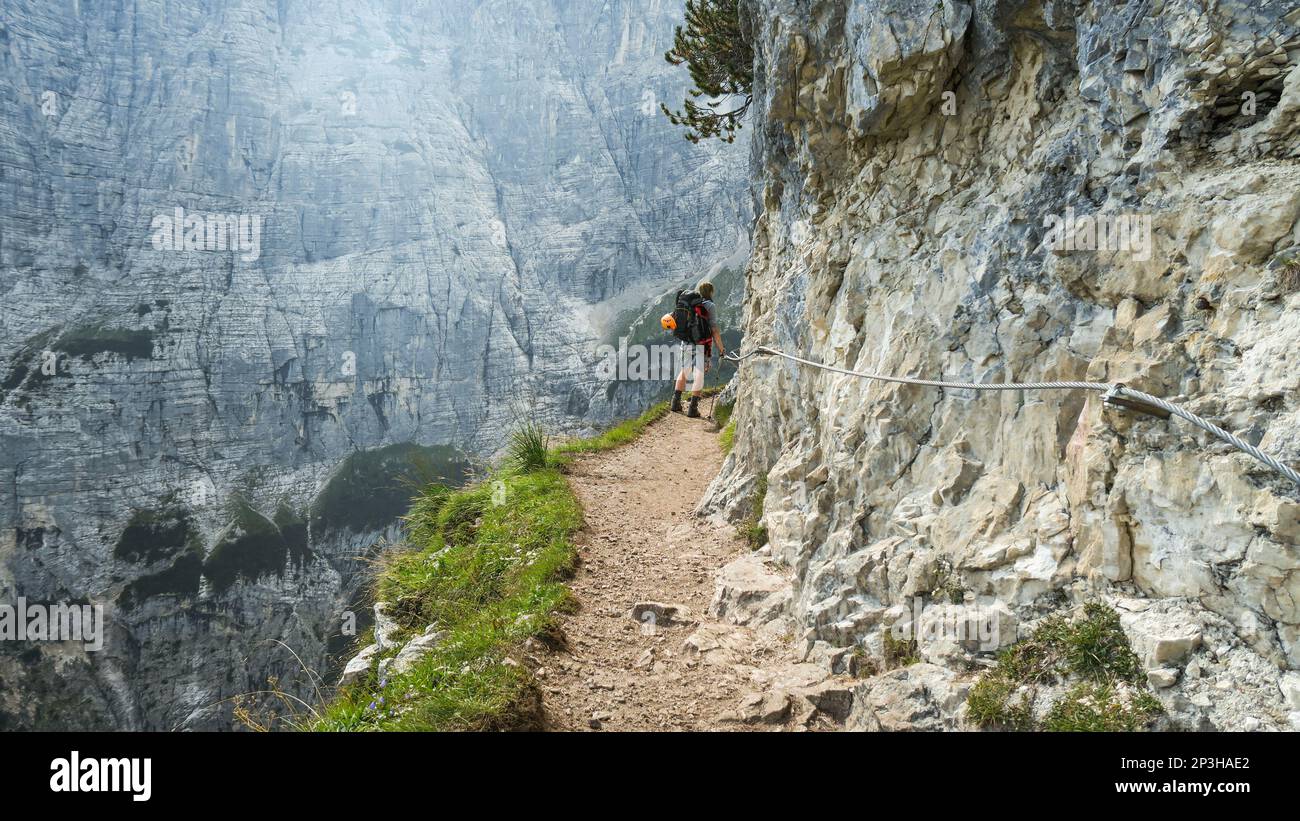 Tourist with equipment on the beautiful via ferrata trail in the alps ...
