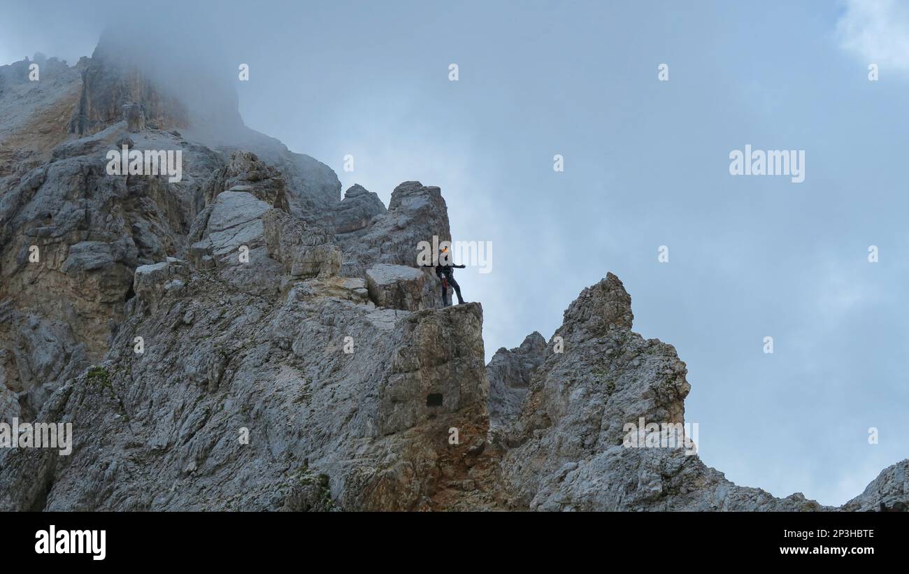 Tourist with equipment on the via ferrata trail in the alps. Dolomites ...