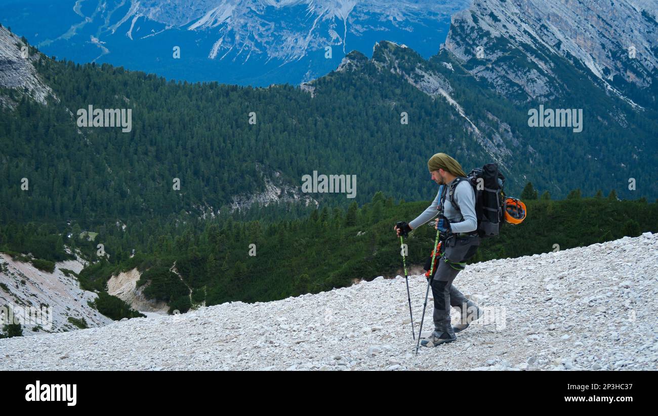 Tourist with equipment on a mountain trail in the Alps. Dolomites ...
