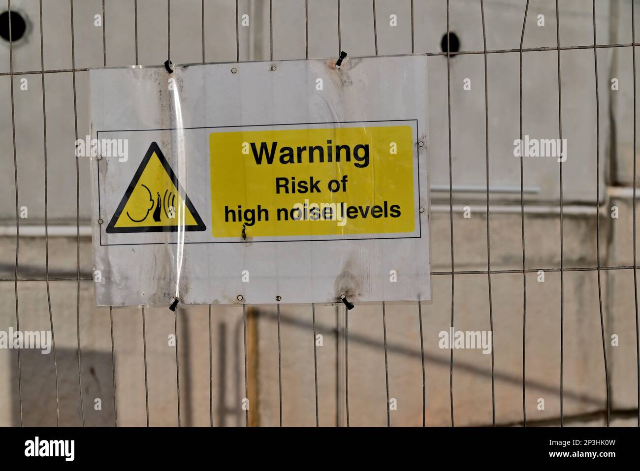 A warning sign on steel fencing at a construction site Stock Photo - Alamy