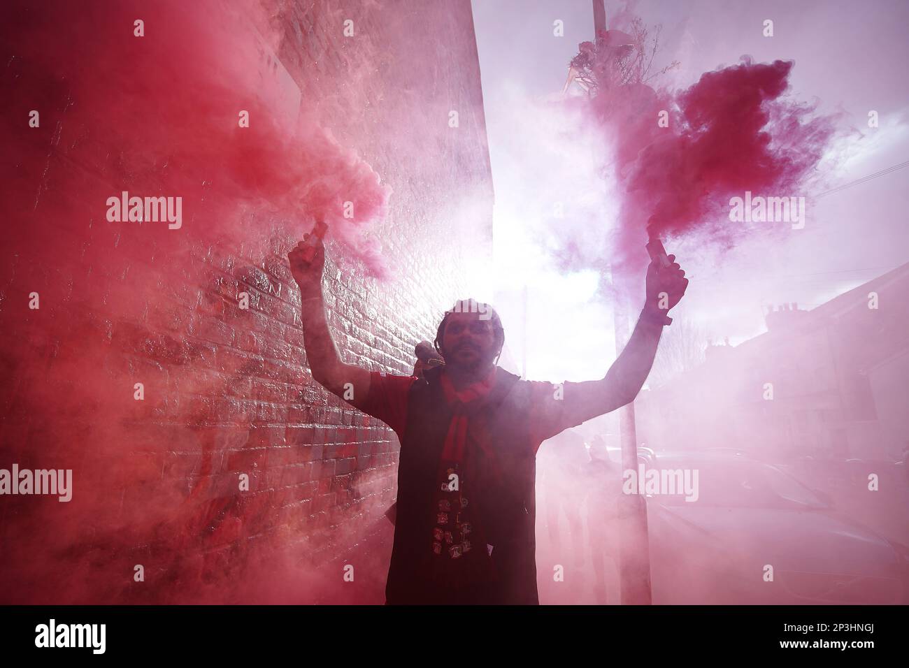 A Liverpool fan sets off a flare on their way to the stadium ahead of ...