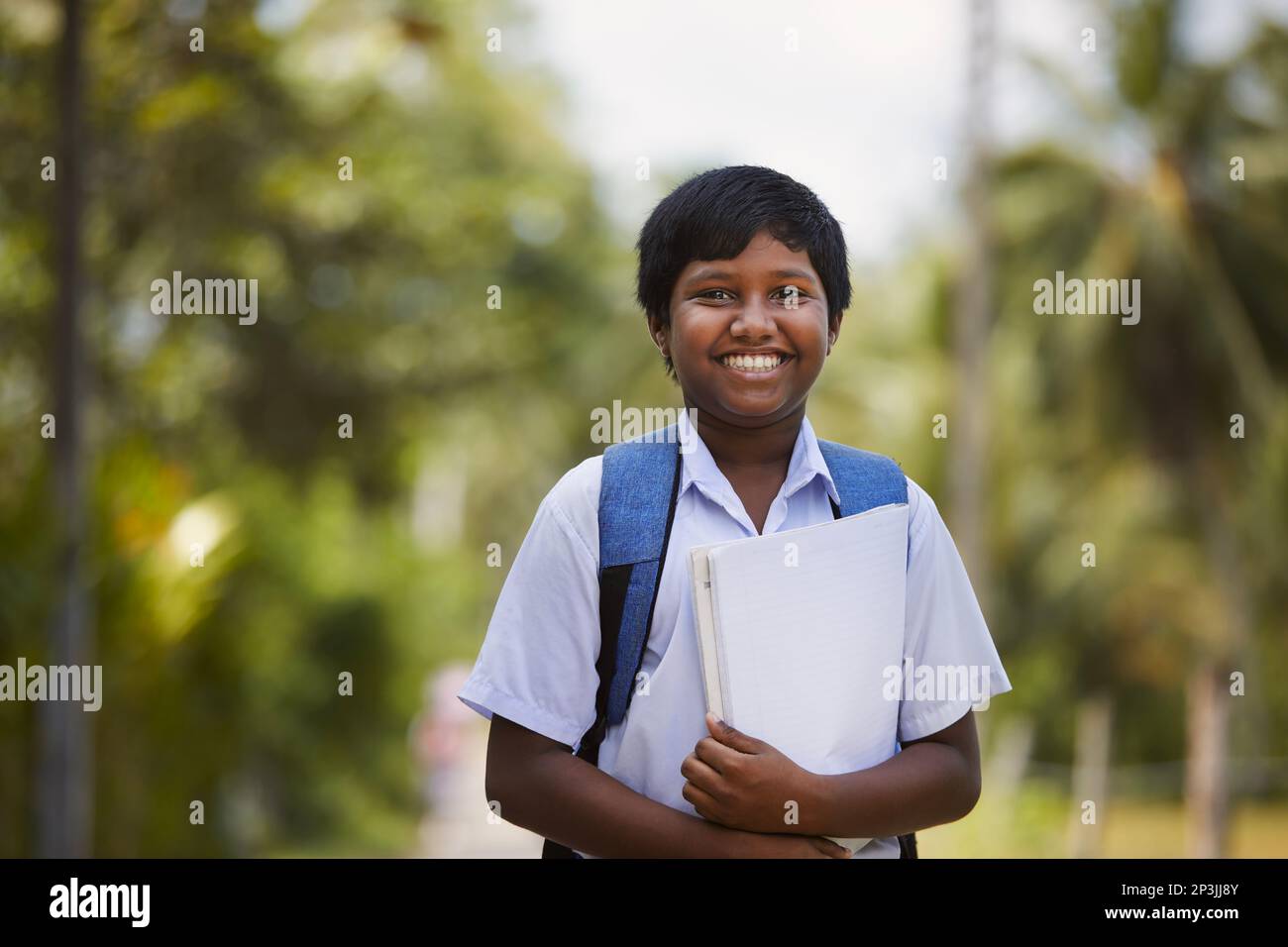 Schoolboy in uniform is walking to school. Portrait boy on rural road ...