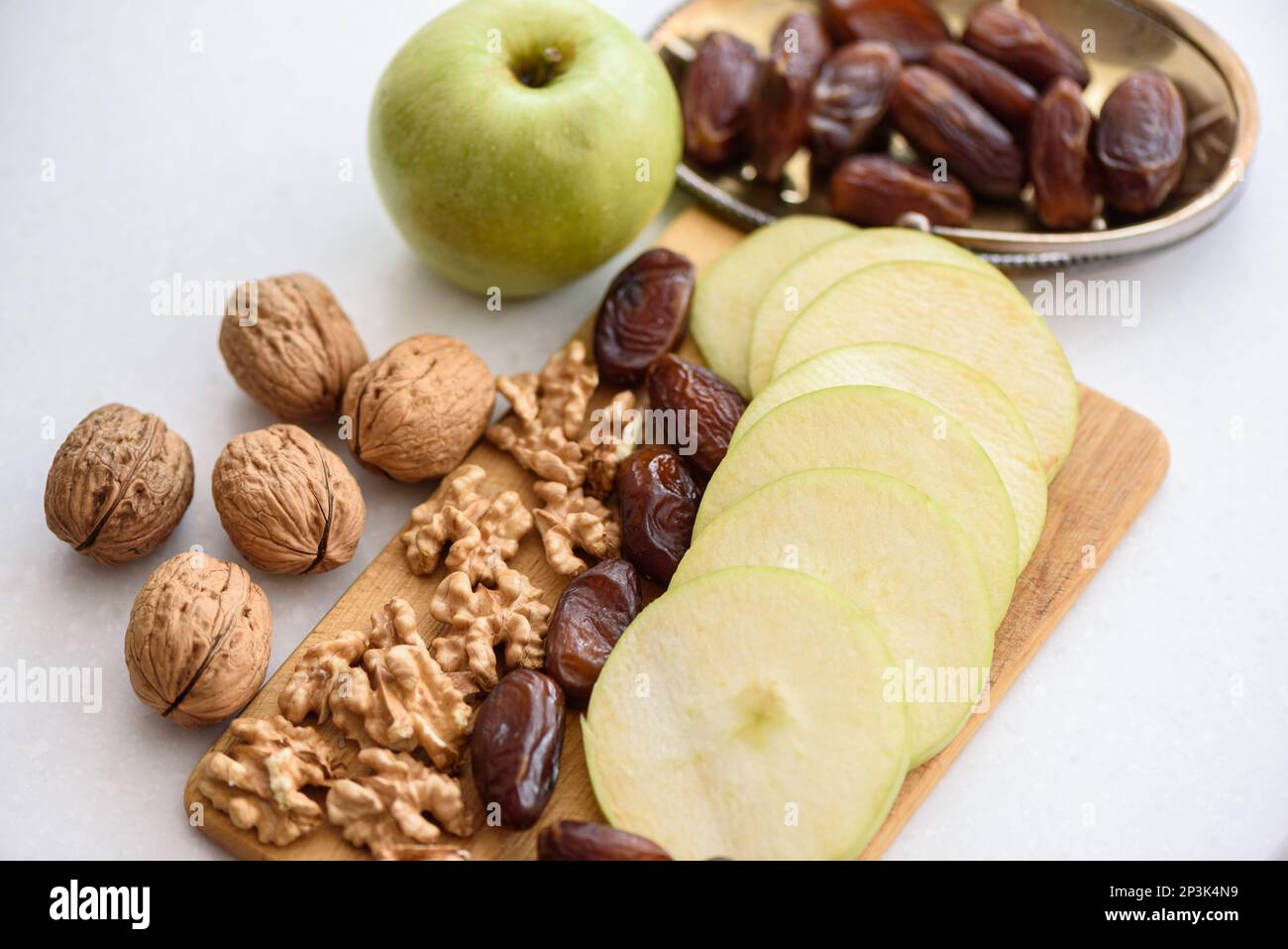 Green apple, walnuts and date fruits on white background Stock Photo ...