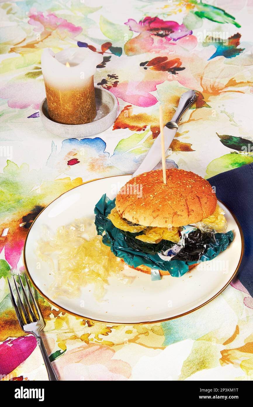 Eating a hamburger, a burger bun with a plastic patty on a plate ...