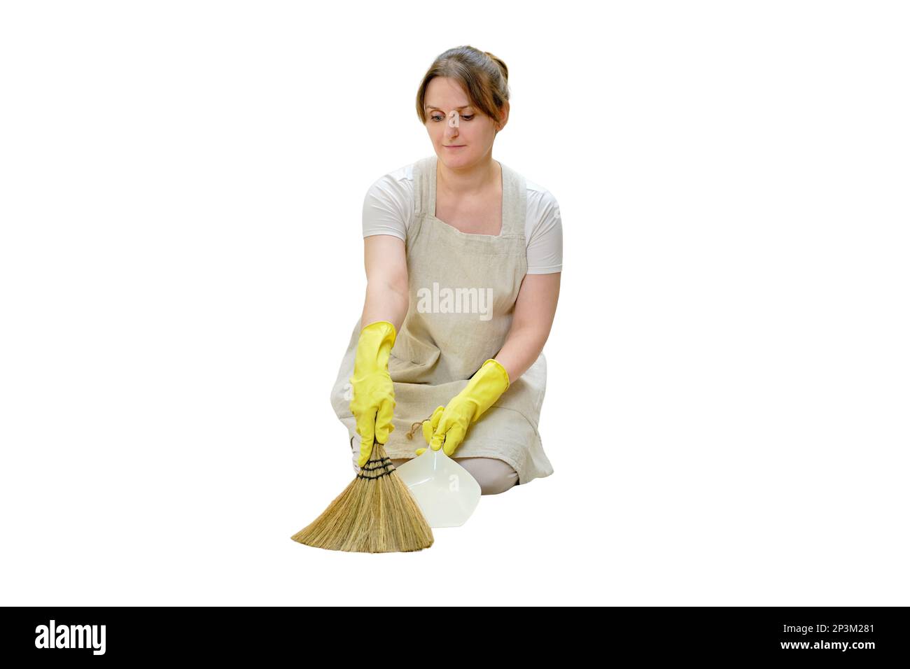 A woman sweeps the floor with a broom when cleaning the home kitchen ...