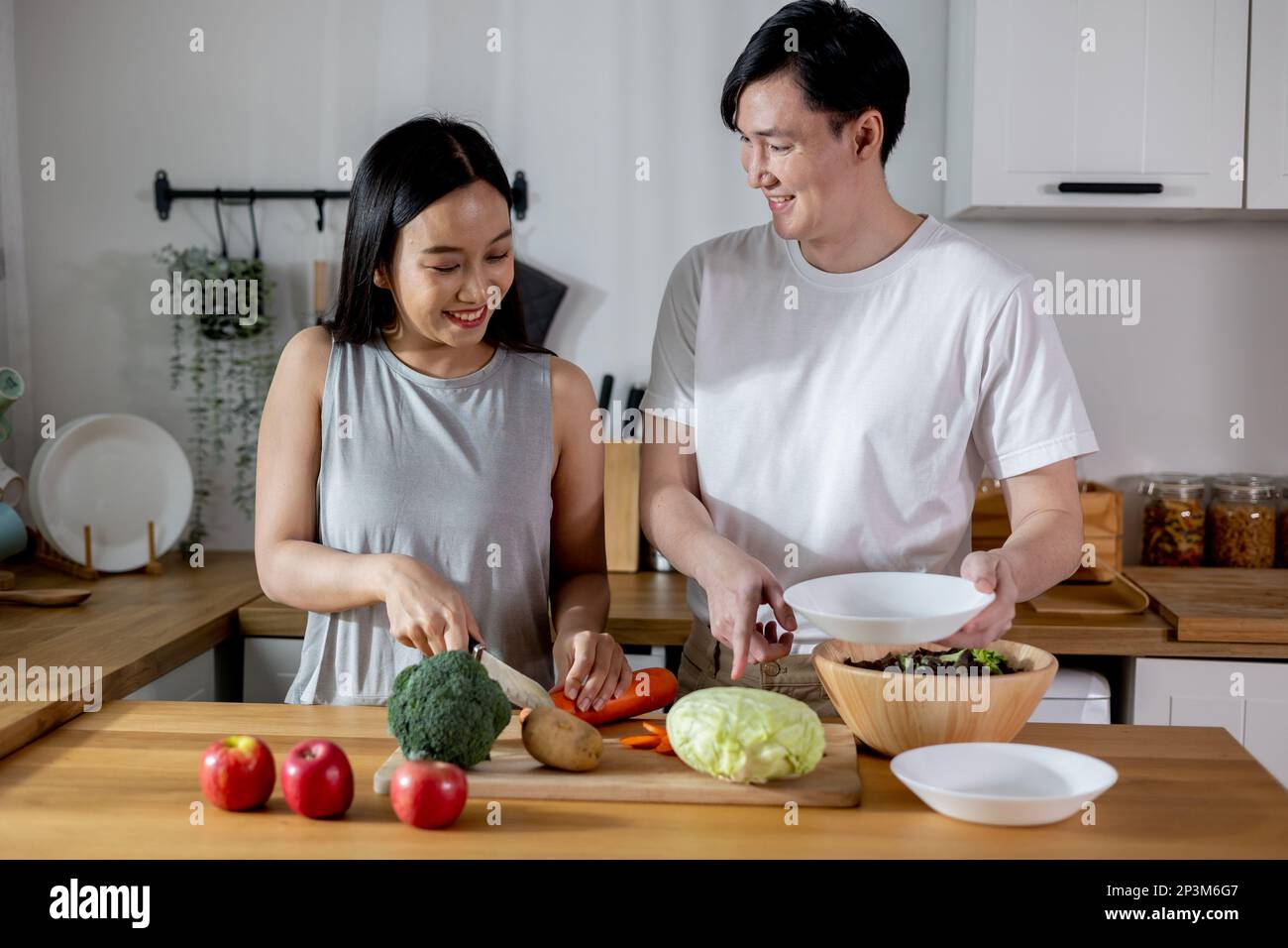 Asian couple in love relationship making a healthy salad together in ...