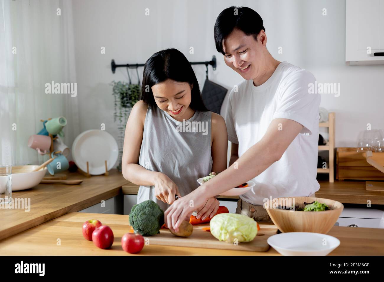 Asian couple in love relationship making a healthy salad together in ...