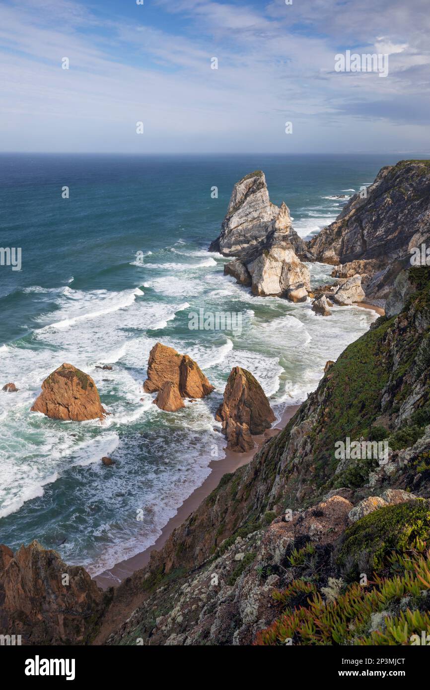 Atlantic Ocean waves rolling onto rocks at Praia da Ursa near Cabo da ...