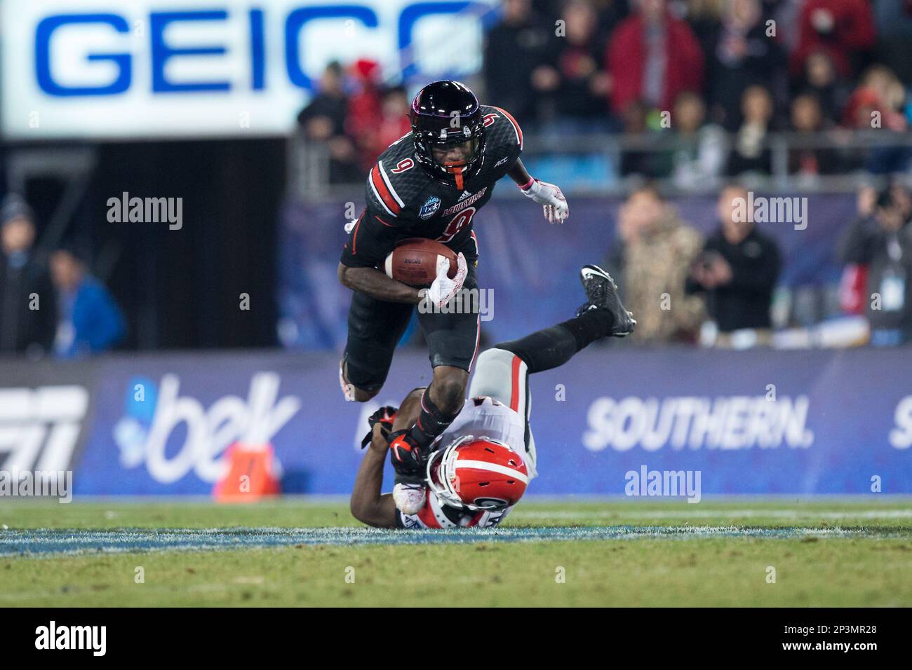 DeVante Parker (9) of the Louisville Cardinals is tackled by Malkom ...