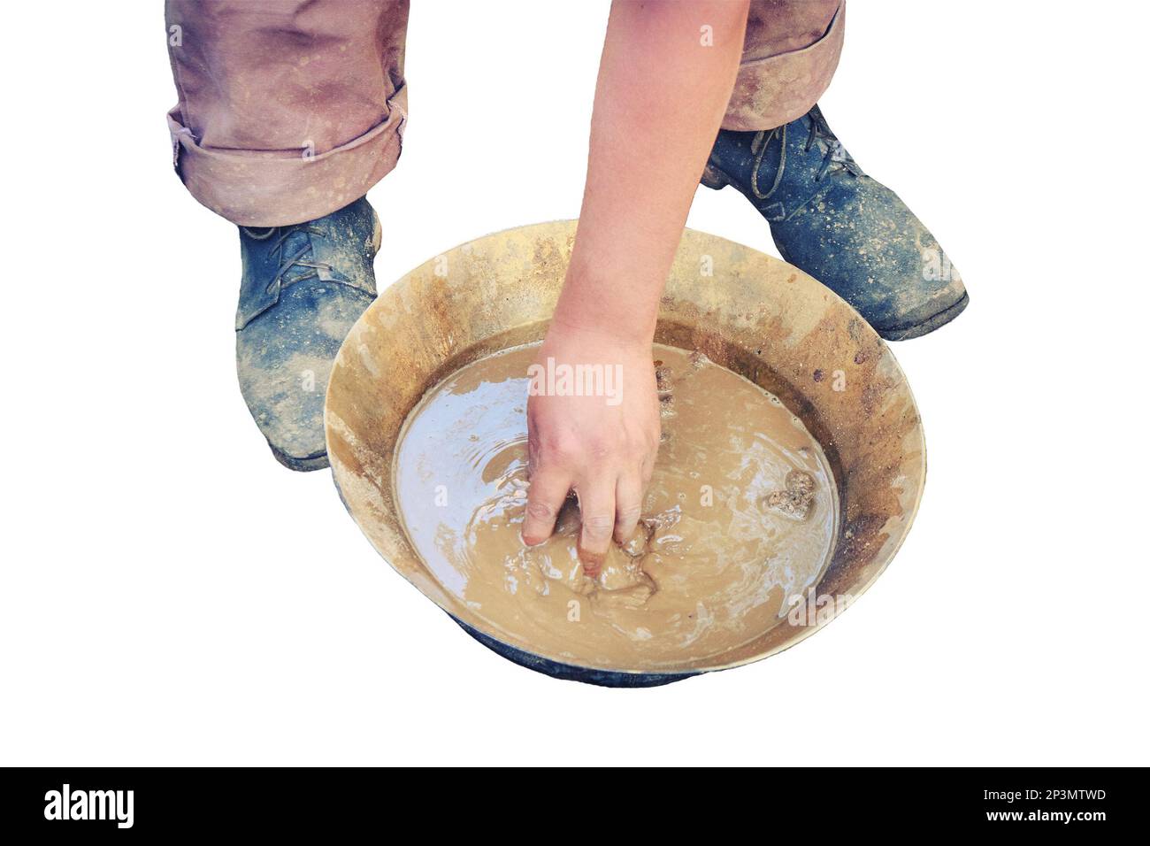 A man washes gold sand in a copper tray, isolated on a white background ...