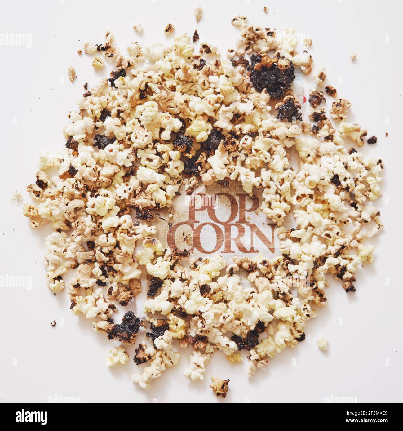 Burnt popcorn from a home microwave. Burn corn kernels on the kitchen table Stock Photo - Alamy